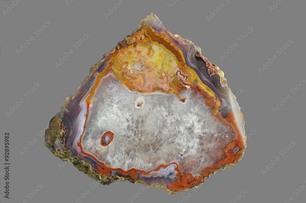 Przekrój agatu, wyizolowany, na szarym tle. Pochodzenie: Maroko, góry ...