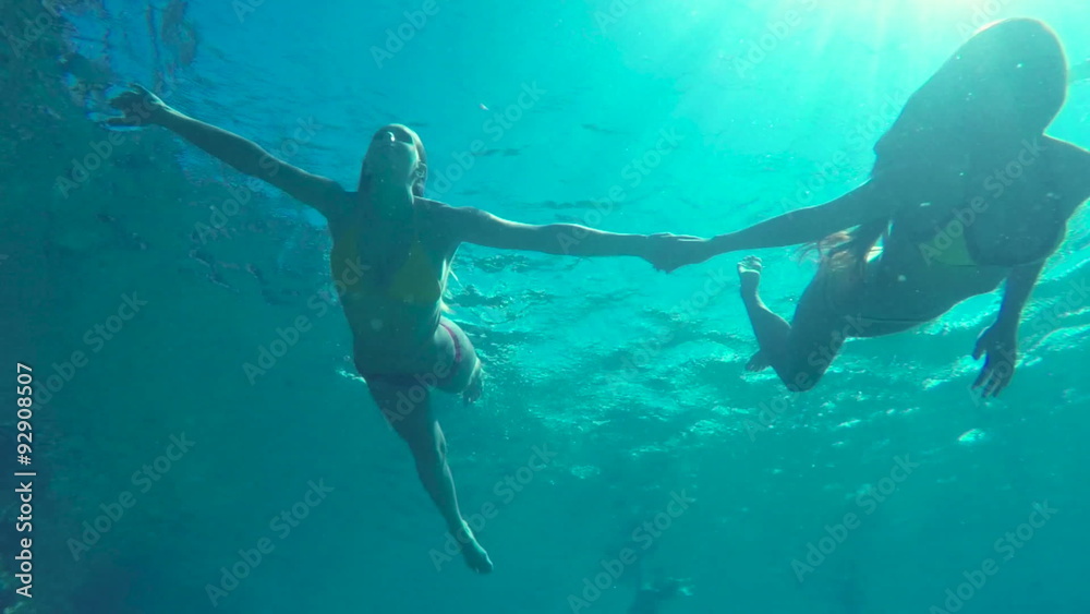 Beautiful Girls In Bikinis Swimming Underwater Holding Hands In Pacific