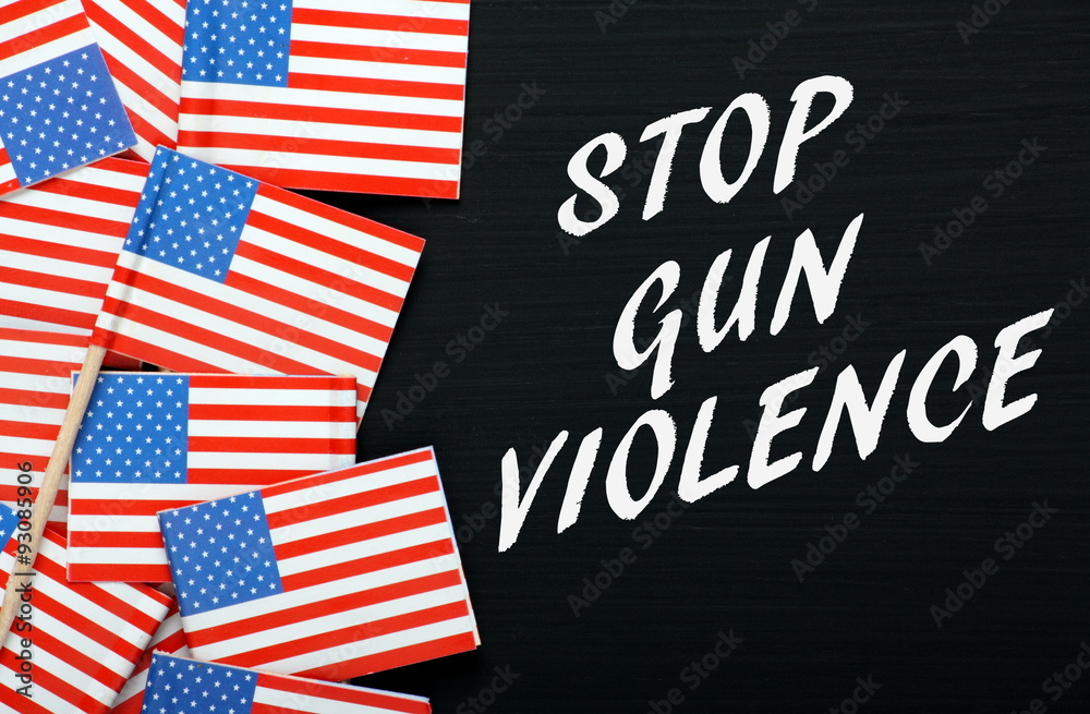 The words Stop Gun Violence in white text on a blackboard alongside ...