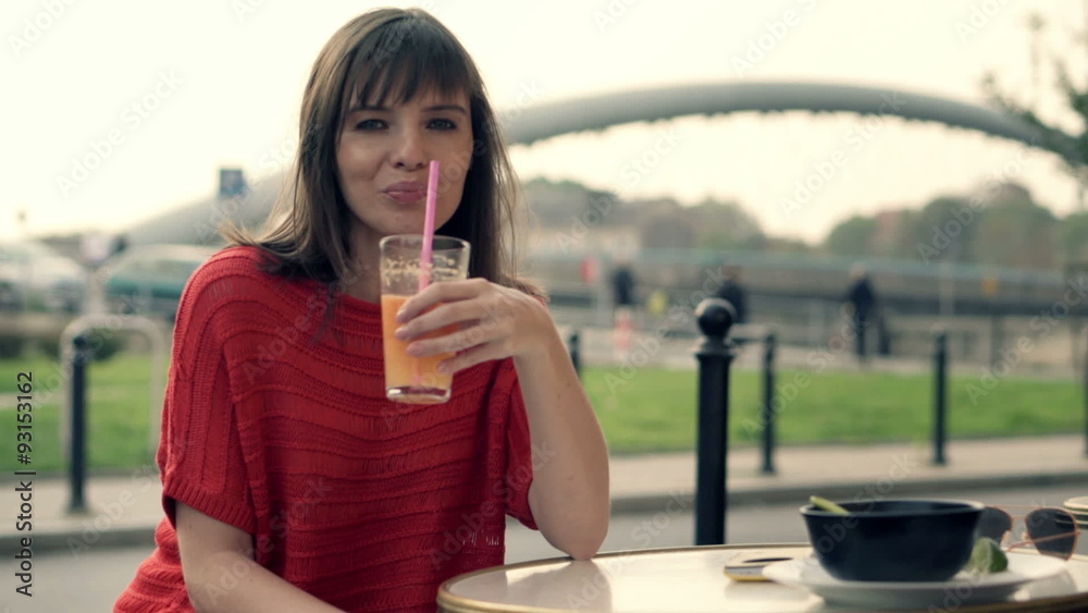 Beautiful woman raising toast to camera and drinking cocktail in cafe ...