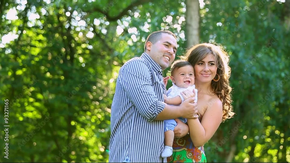 Beautiful happy family posing for photographer at trees background ...