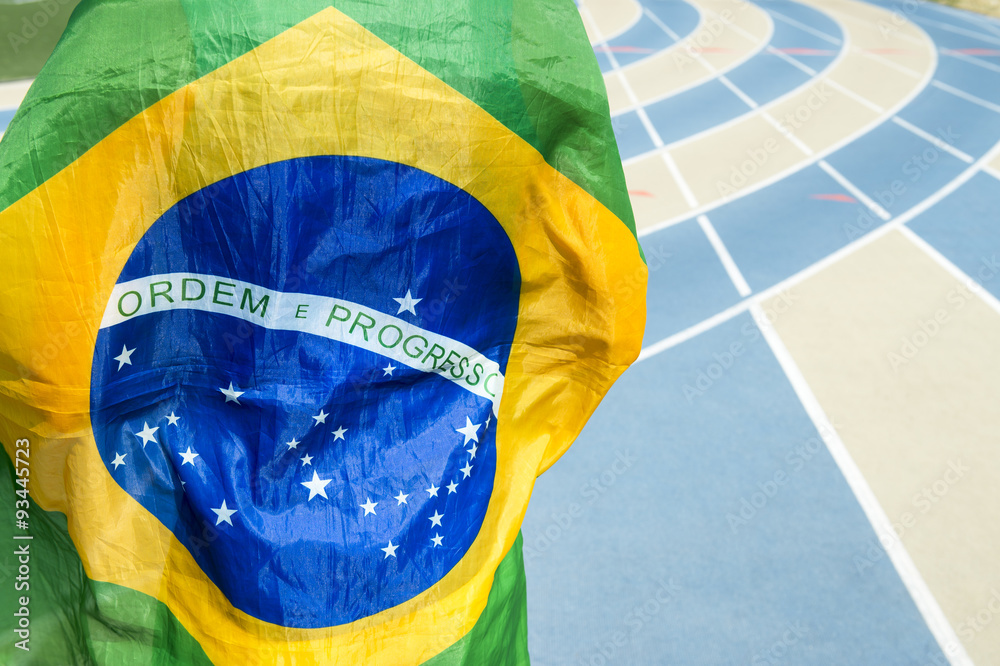 Athlete wearing Brazilian flag against a blue and tan running track ...