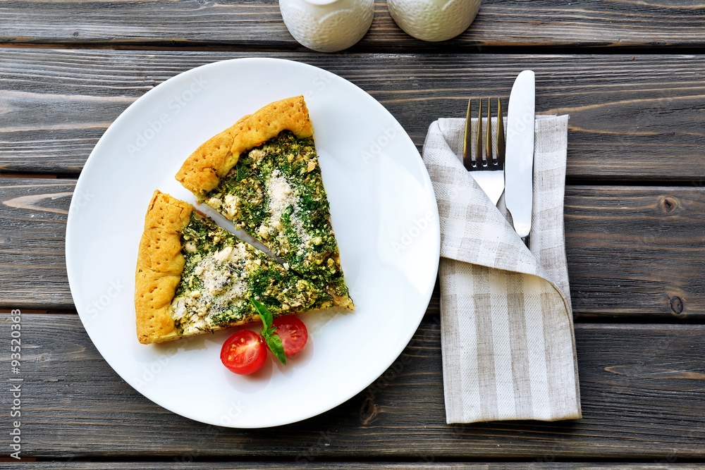 Slices of open pie with spinach and tomato cherry on table close up ...