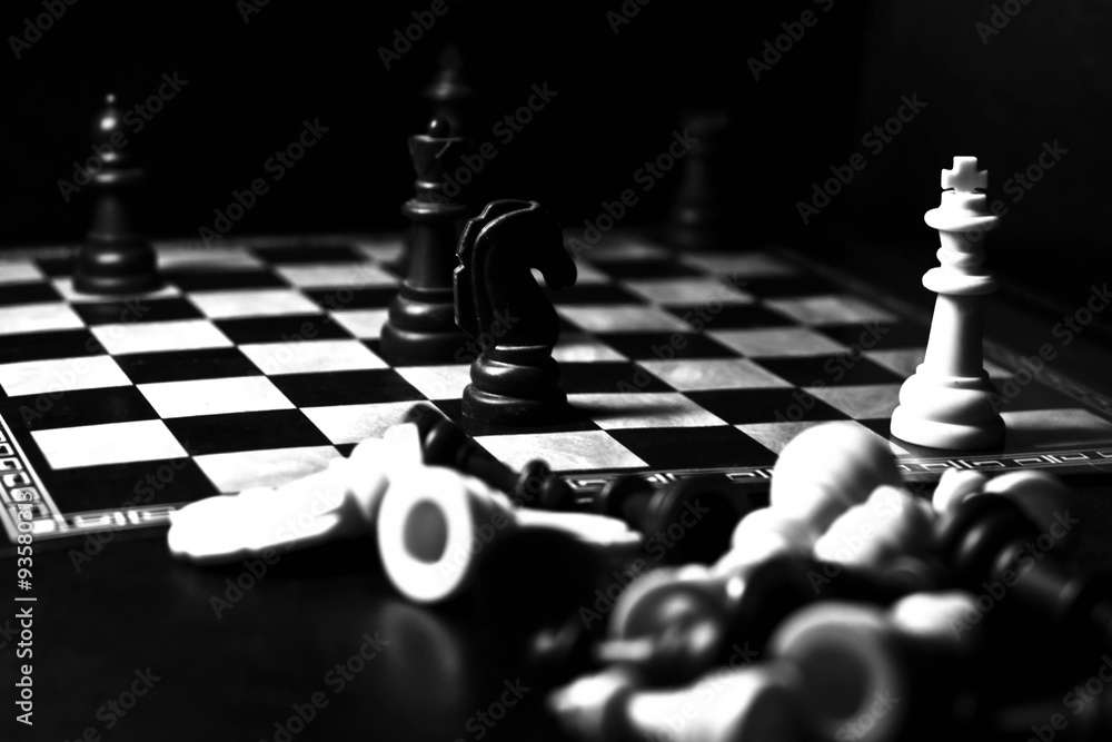 Chess pieces in a war on chess board on black background. Stock Photo ...