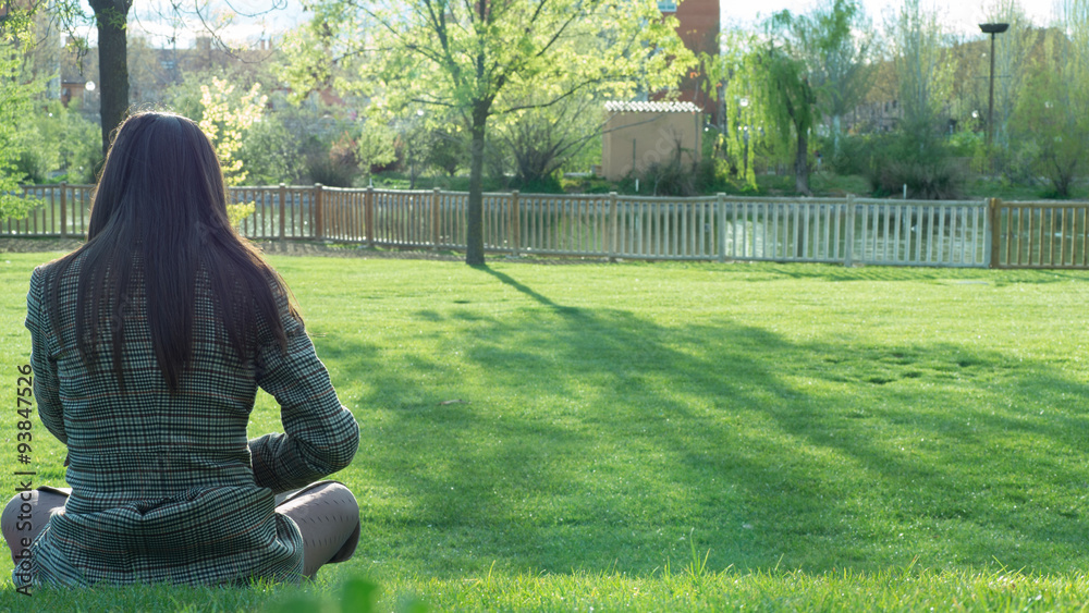 mujer sentada de espaldas en la hierba Stock Photo | Adobe Stock