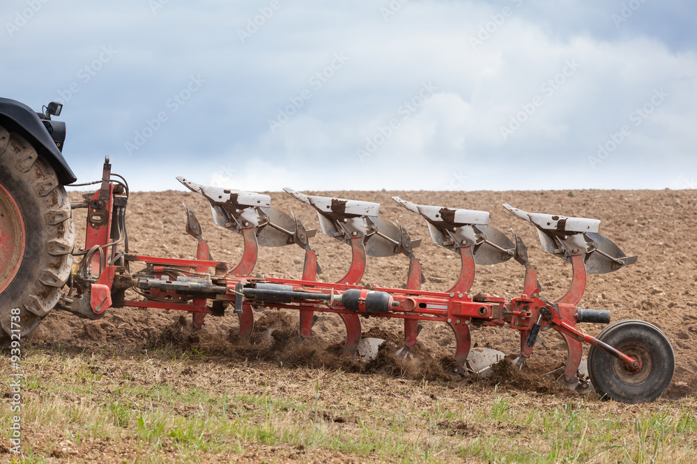 Detail of an agricultural plough in action ploughing an overwintered ...