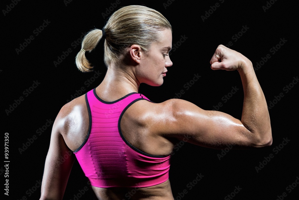 Muscular woman flexing her arm Stock Photo | Adobe Stock