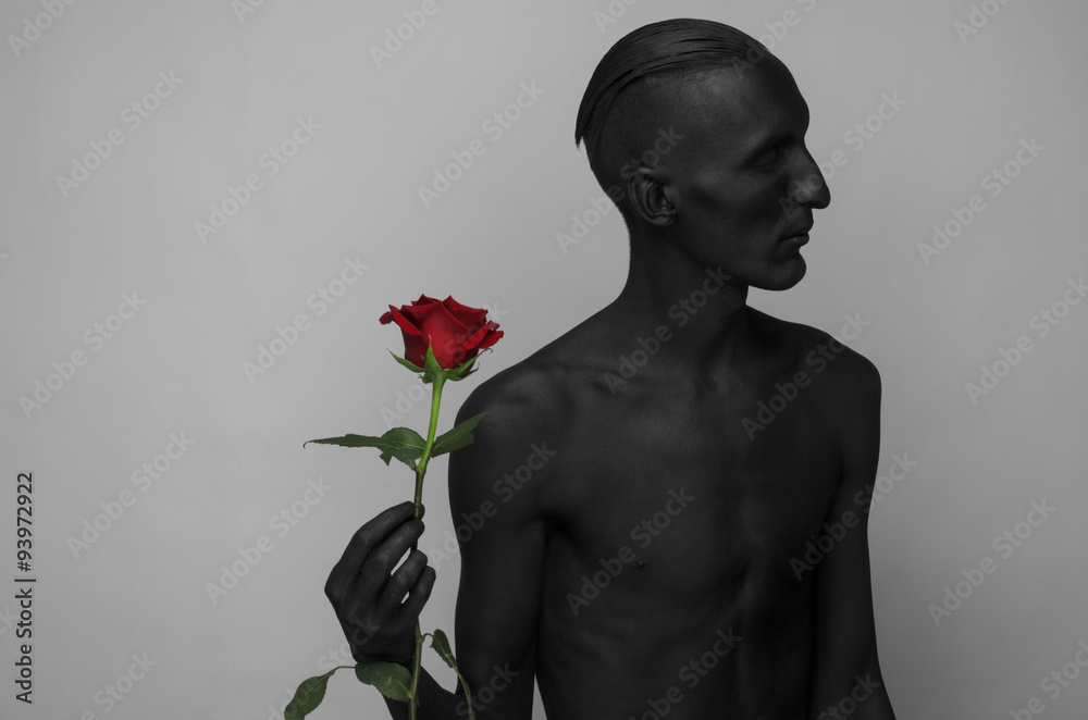 Gothic and Halloween theme: a man with black skin holding a red rose ...