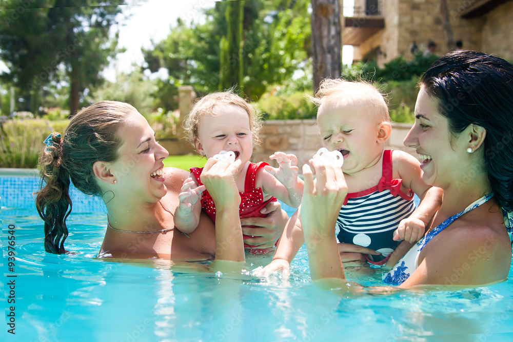 Two happy little girl with mothers in swimming pool Stock Photo | Adobe ...