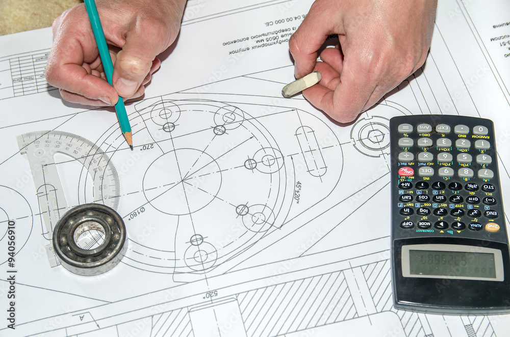 engineering drawings with human hands drawing a project by pencil on ...