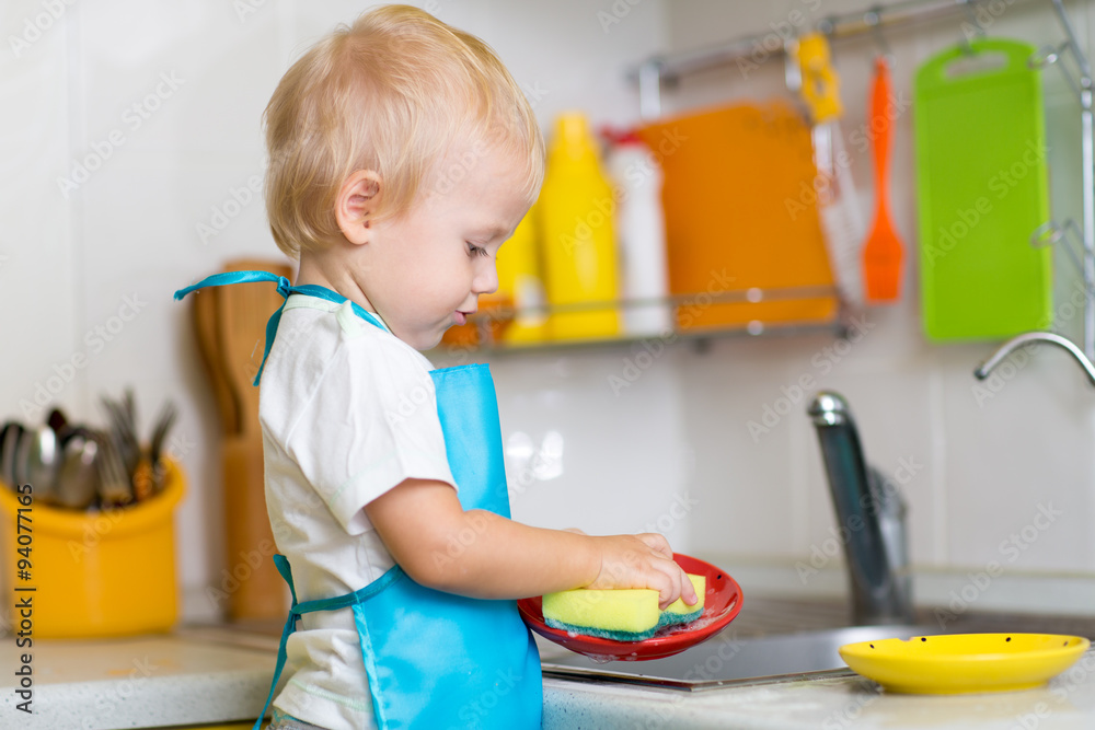 Child washing dishes in a domestic kitchen Stock Photo | Adobe Stock