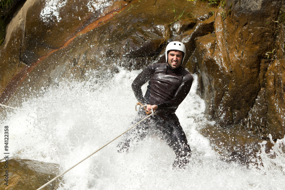 spelunking grown man descending an ecuadorian falls in a correct ...