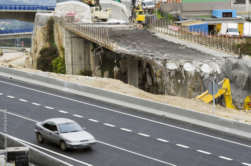 excavator demolition vehicle heavy equipment tearing down a bridge over ...