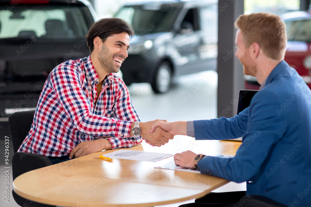 Man buying a car in dealership they are shaking hands to close t Stock ...