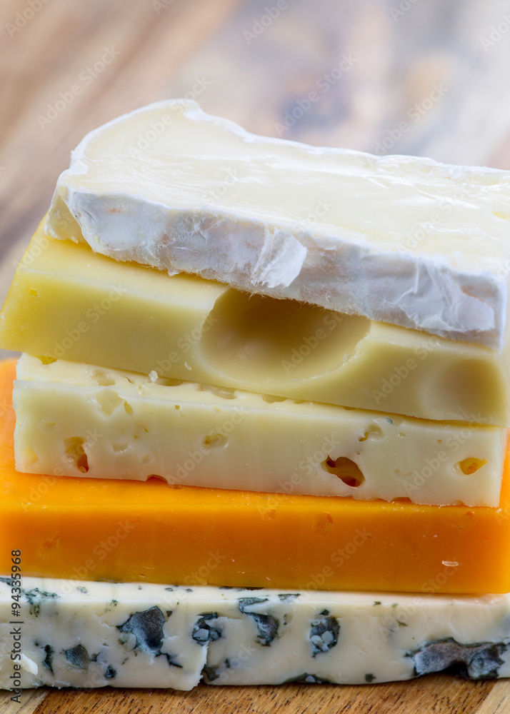 Slices of blue cheese, brie cheese, swiss cheese, red cheddar, maasdam ...
