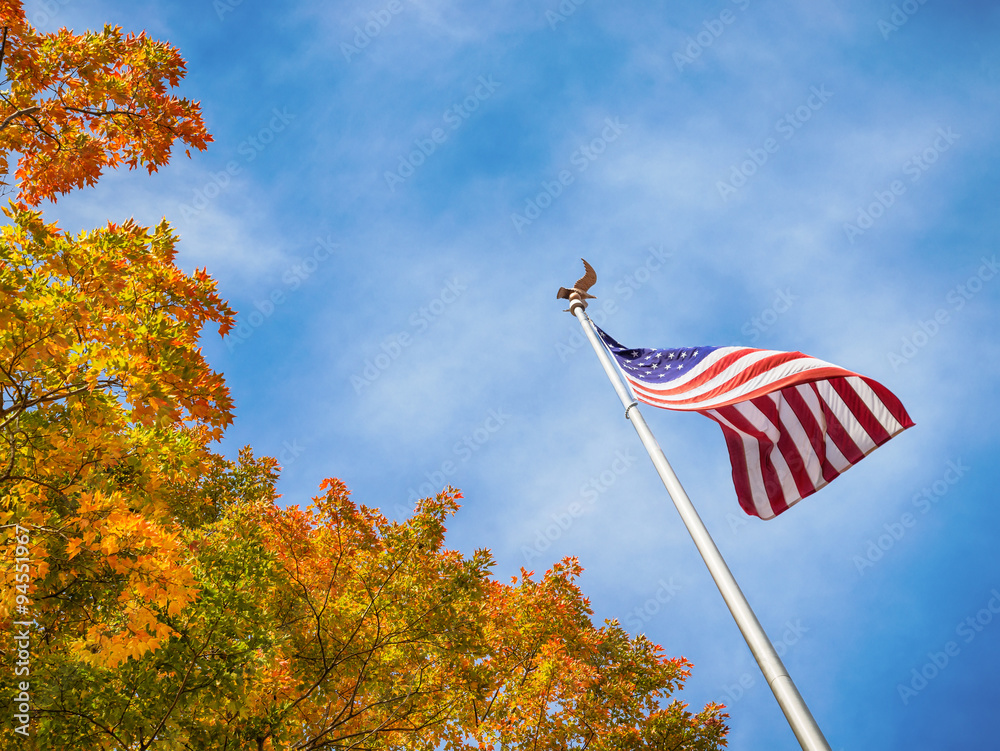 American flag waving in the wind with golden autumn tree tops Stock ...