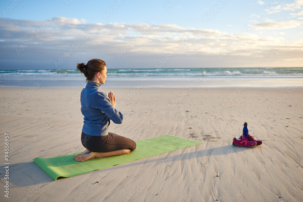 Woman doing breathing exercises on a yoga-mat at the beach Stock Photo ...