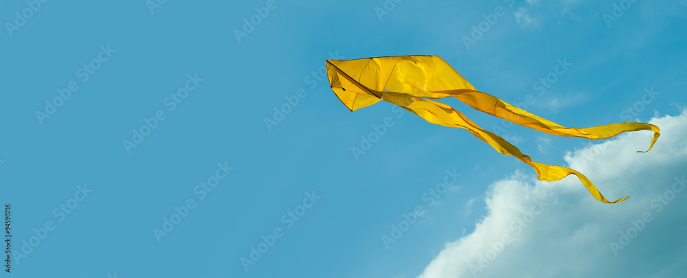 Yellow kite flying in the sky. Cloudy day. Blue background. Stock Photo ...