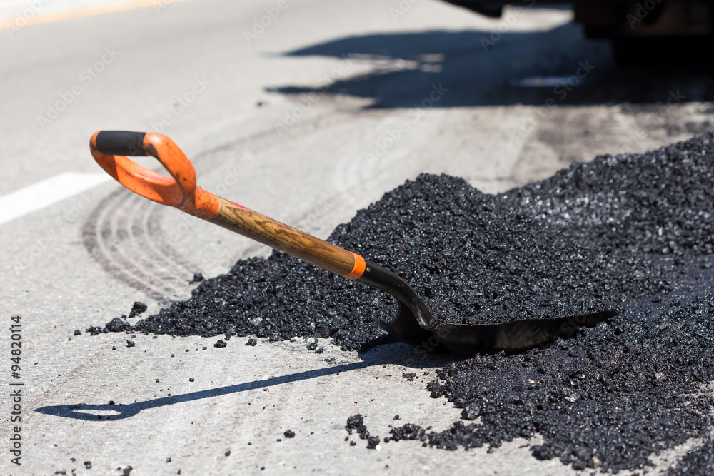 Shovel for road construction works in a heap of new asphalt Stock Photo ...