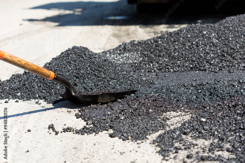 Shovel for road construction works in a heap of new asphalt Stock Photo ...