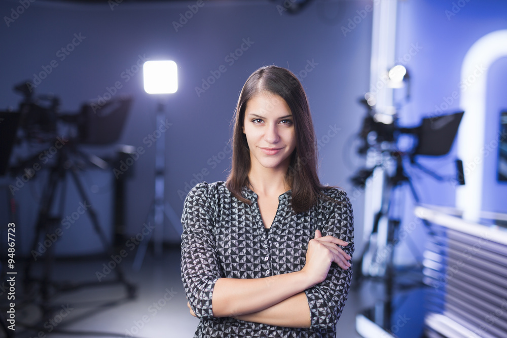 Young beautiful brunette television announcer at studio standing next ...