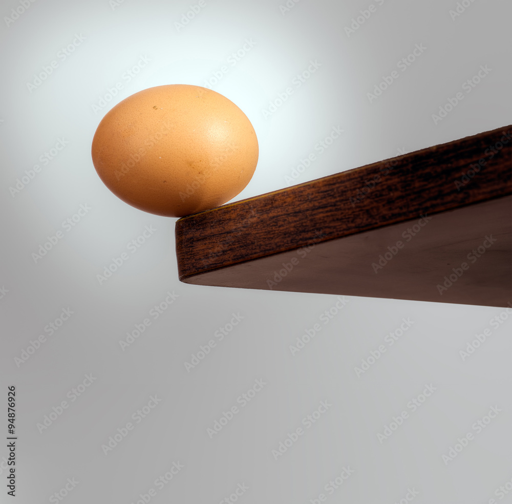 Teetering on the brink, edge. Egg on table. Concept, metaphor. Stock ...