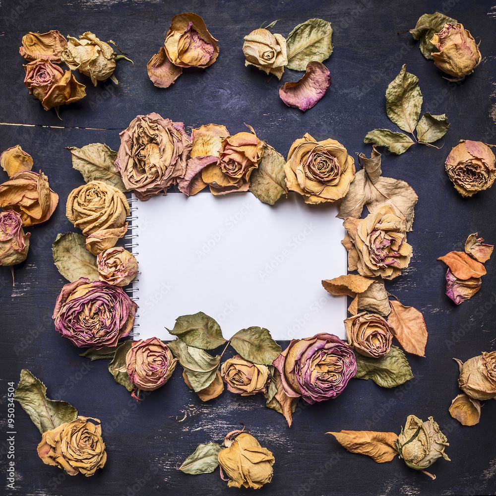 many buds withered roses with petals, laid out around a sheet of paper ...