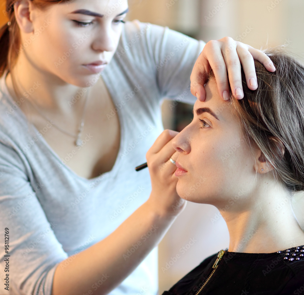 Backstage scene: Professional Make-up artist doing glamour model makeup ...