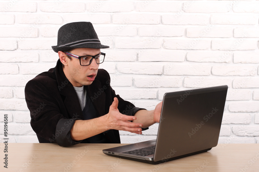 Shocked young business man using laptop looking at computer screen ...
