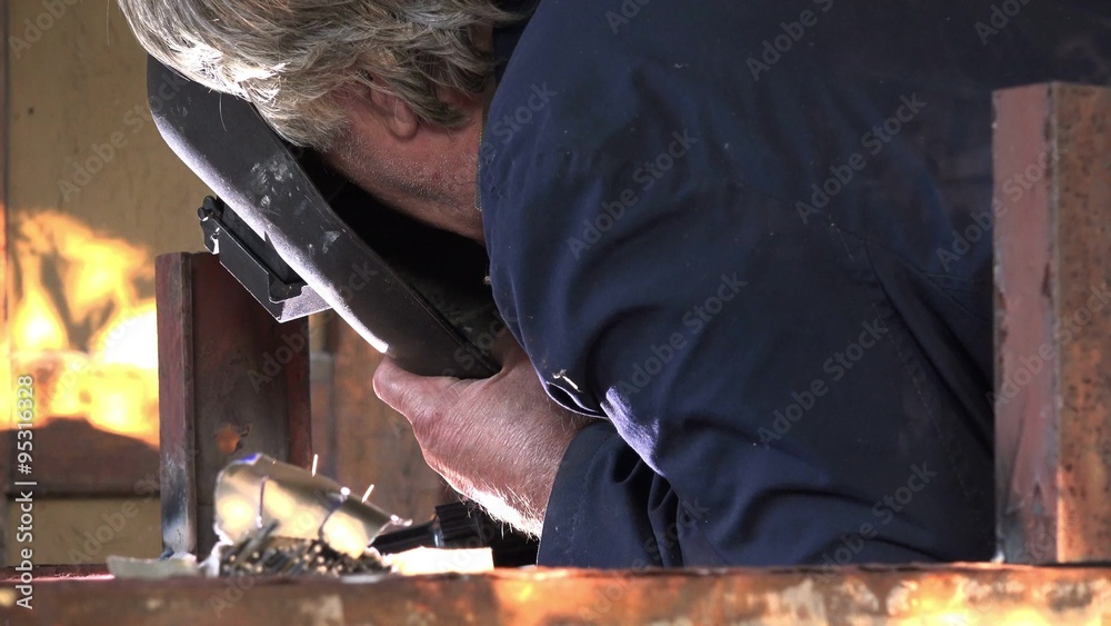 Shielded metal arc welding in workshop, male welder using electrode to ...