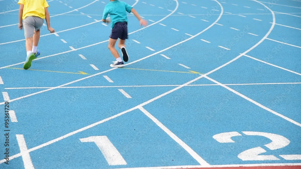 Young Asian boy running on blue track in the stadium in day time to ...