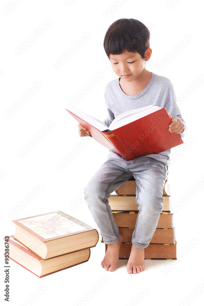 Asian cute boy reading book while sitting on stack of books. whi Stock ...