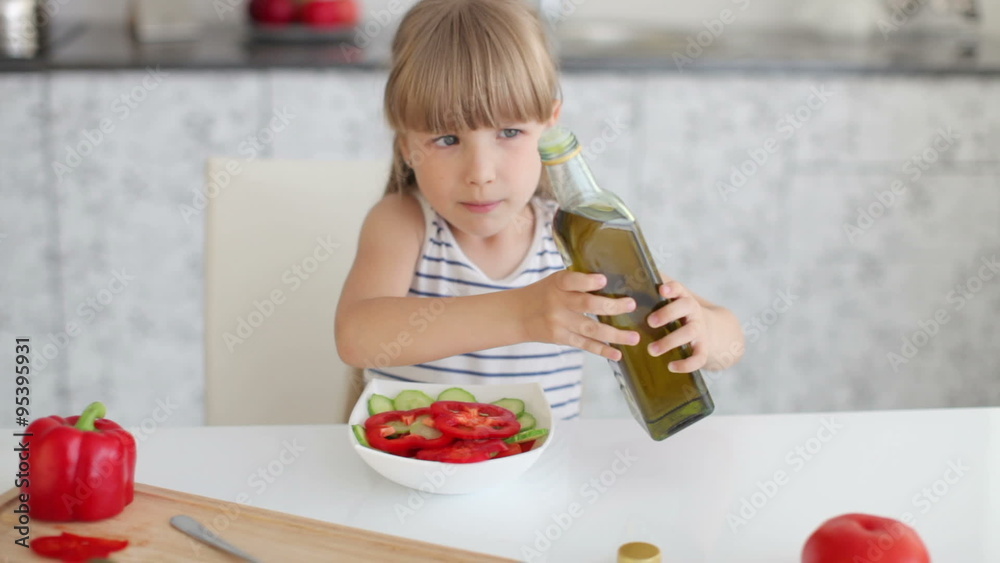 Cute little girl sitting at kitchen table and pouring olive oil from ...