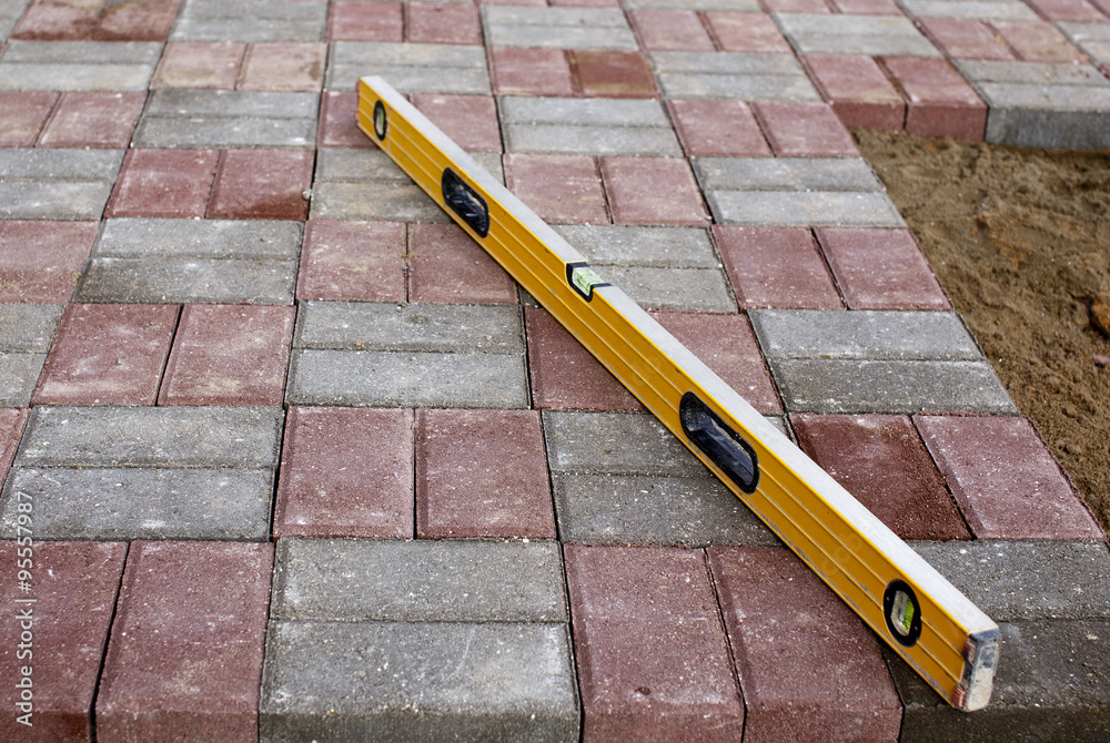 paving slabs and tools for measuring the level. Paving works of paving ...