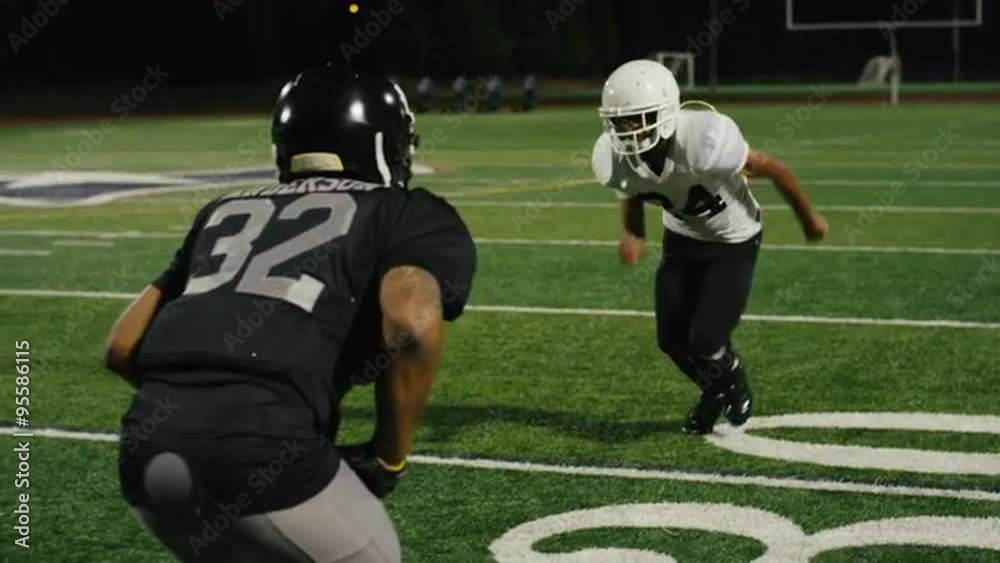 A football player runs down the field and catches the ball and runs for ...