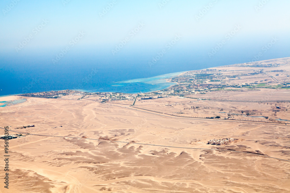 Aerial view at the sandy desert terrain and Red sea coast with resorts ...