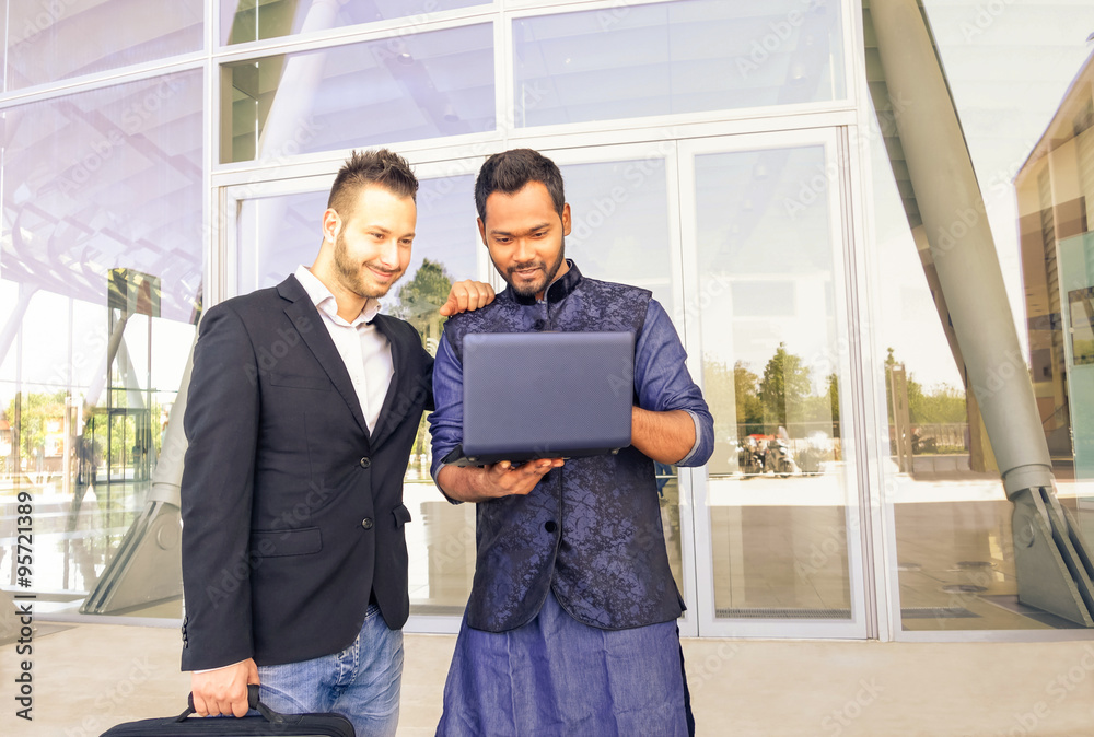 Young indian businessman shows laptop at colleague - Smiling ...