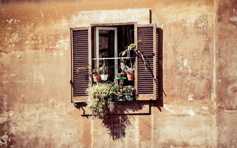 Very cosy and cute window with wooden shutters and hanging flower pots ...