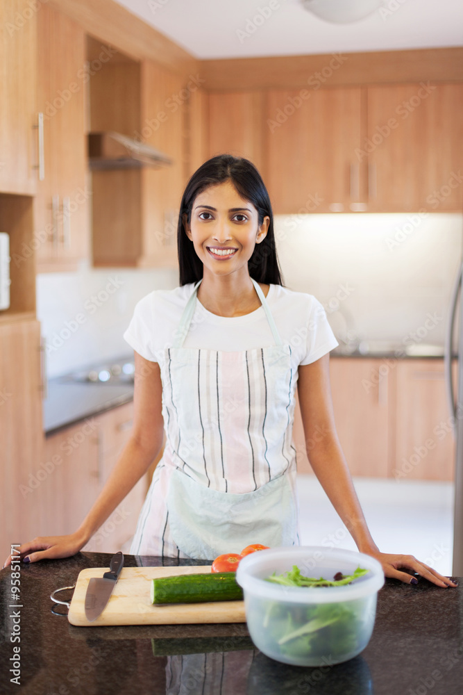 Foto Stock young indian woman in home kitchen | Adobe Stock