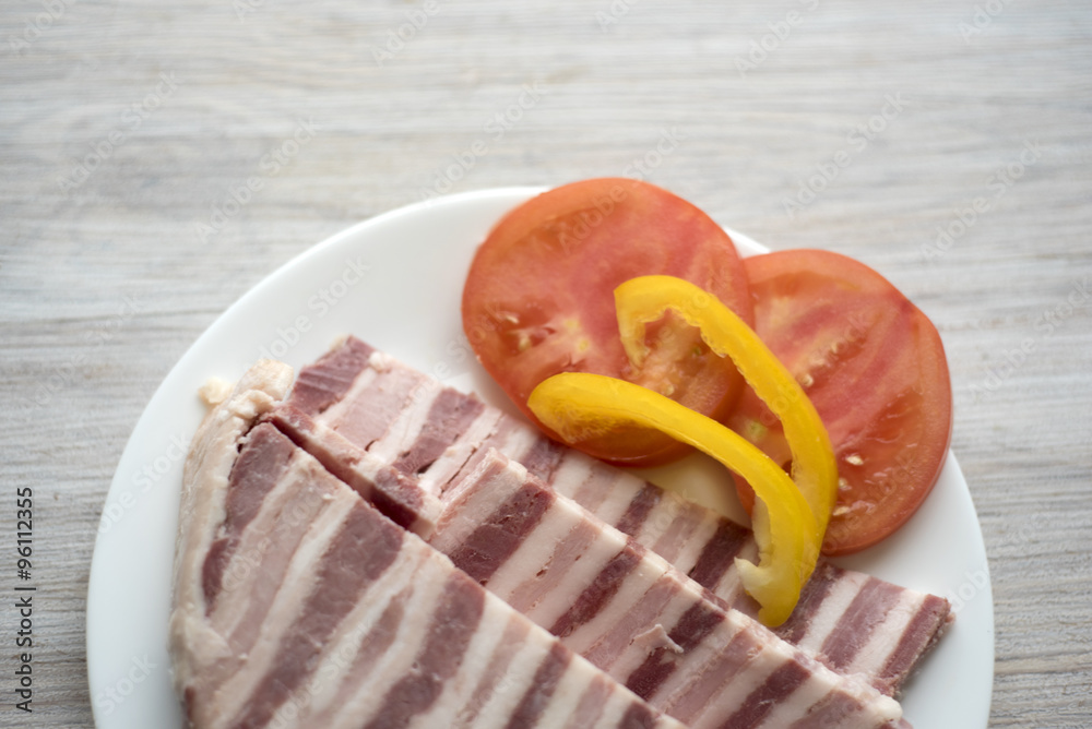 Puff fat meat sliced. With tomato and pepper. Photos | Adobe Stock