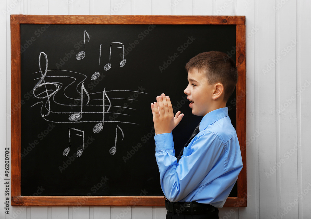 Young cute schoolboy posing at the blackboard with musical notes Stock ...