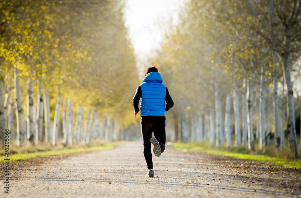 sport man running outdoors in off road trail ground with trees under ...