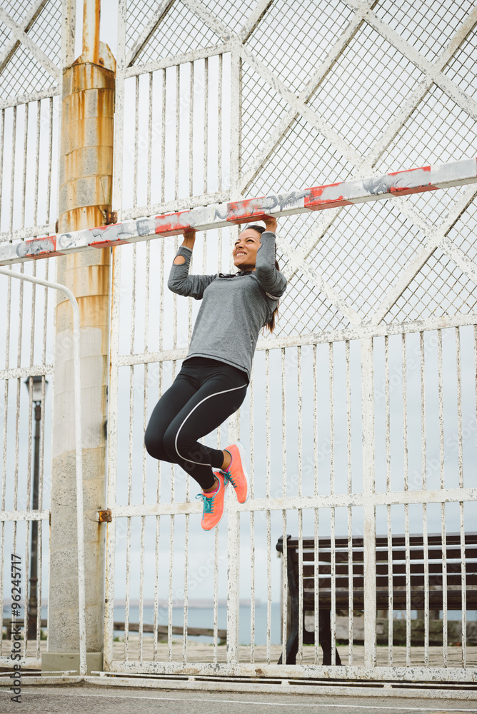 Fitness woman doing pull ups strength workout. Female athlete training ...
