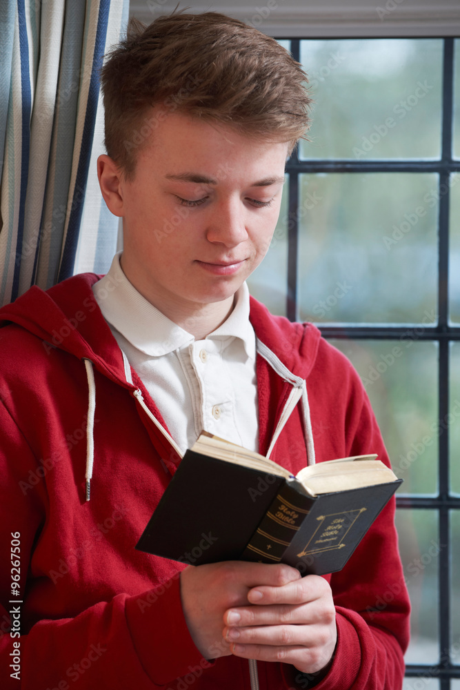 Teenage Boy Reading Bible At Home Stock Photo | Adobe Stock