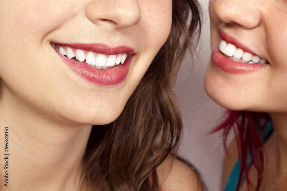Two women whispering and smiling Stock Photo | Adobe Stock