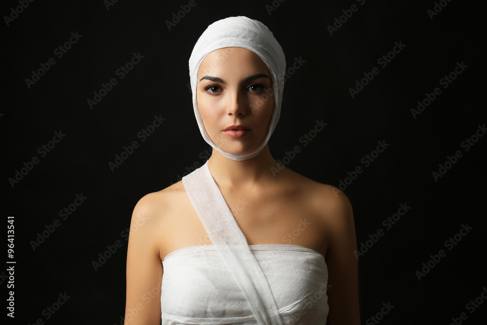 Young beautiful woman with a gauze bandage on her head and chest, on ...