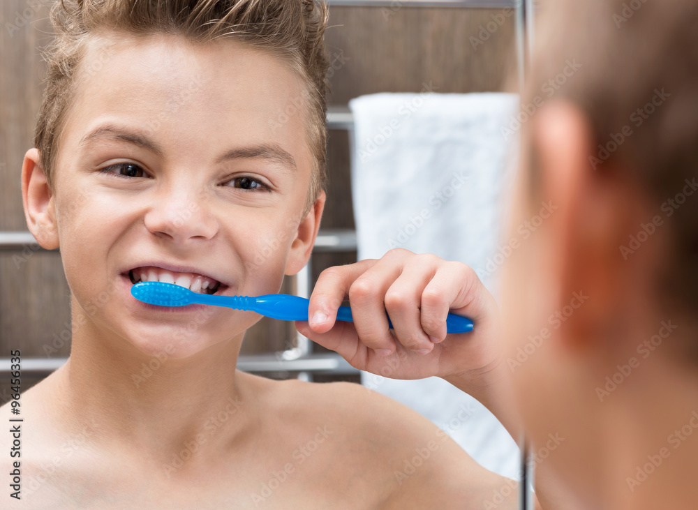 Teen boy brushing his teeth Stock Photo | Adobe Stock