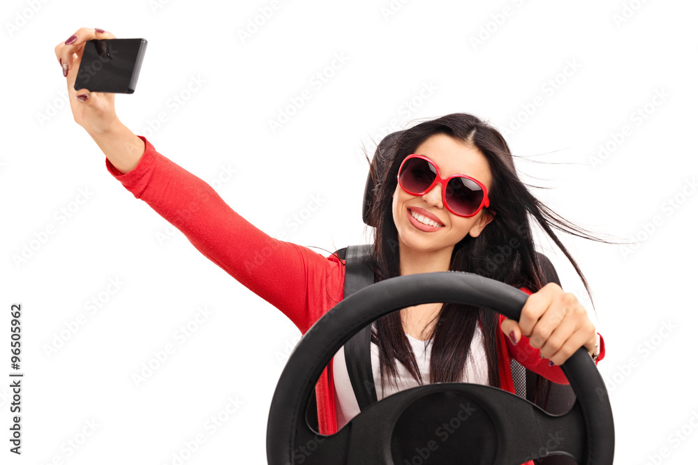 Young woman taking a selfie while driving a car Stock Photo | Adobe Stock