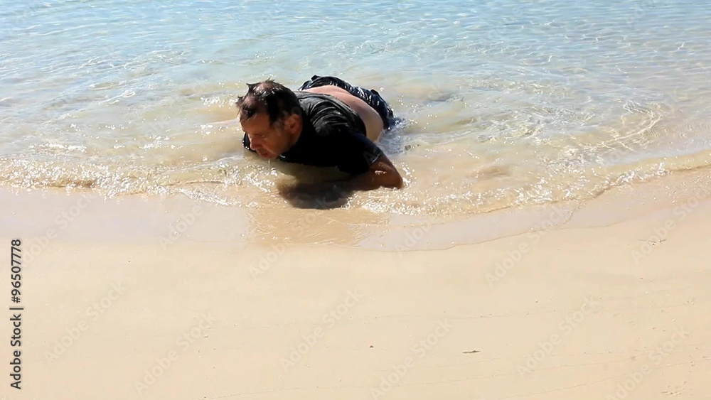 exhausted man crawled out of the sea and lying on the beach Stock ビデオ ...