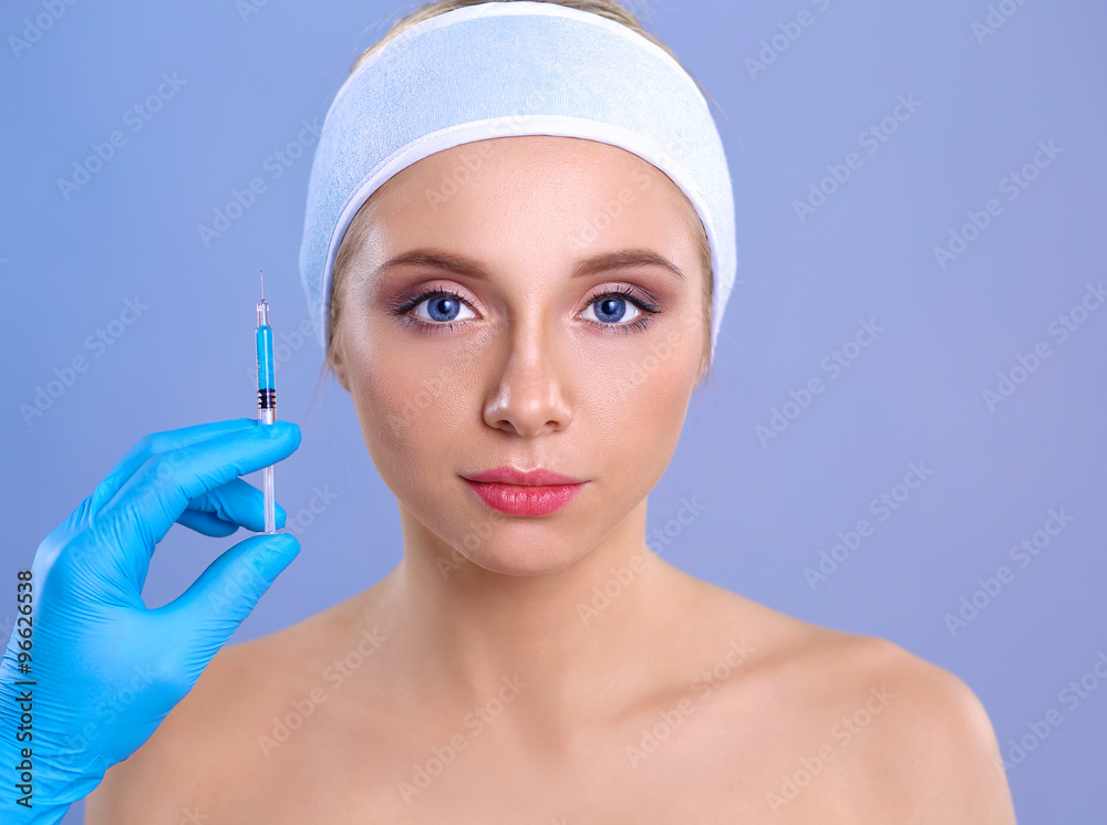 Cosmetic injection on the pretty woman face. Isolated on gray ...